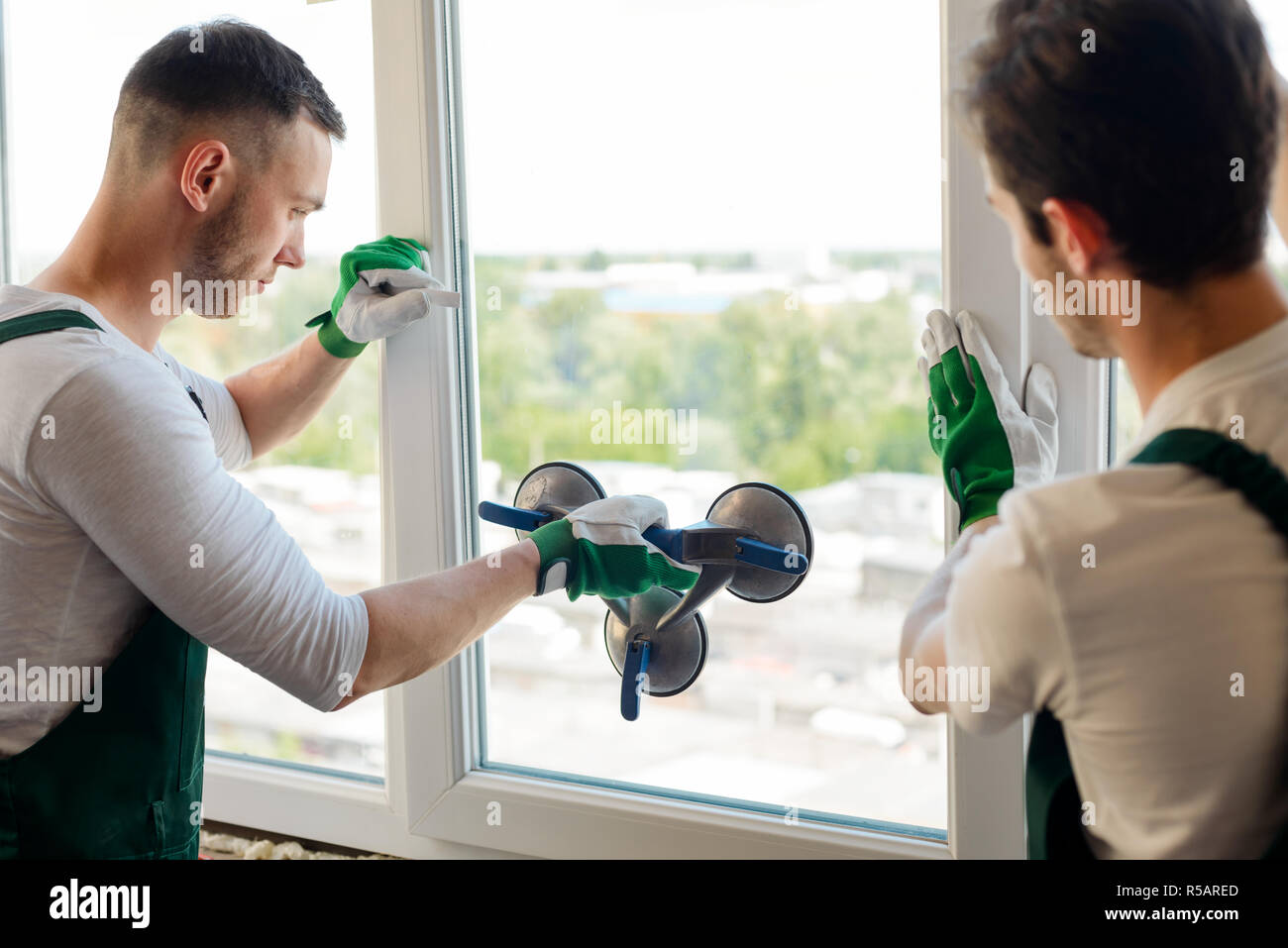 Young guys installing a window Stock Photo - Alamy