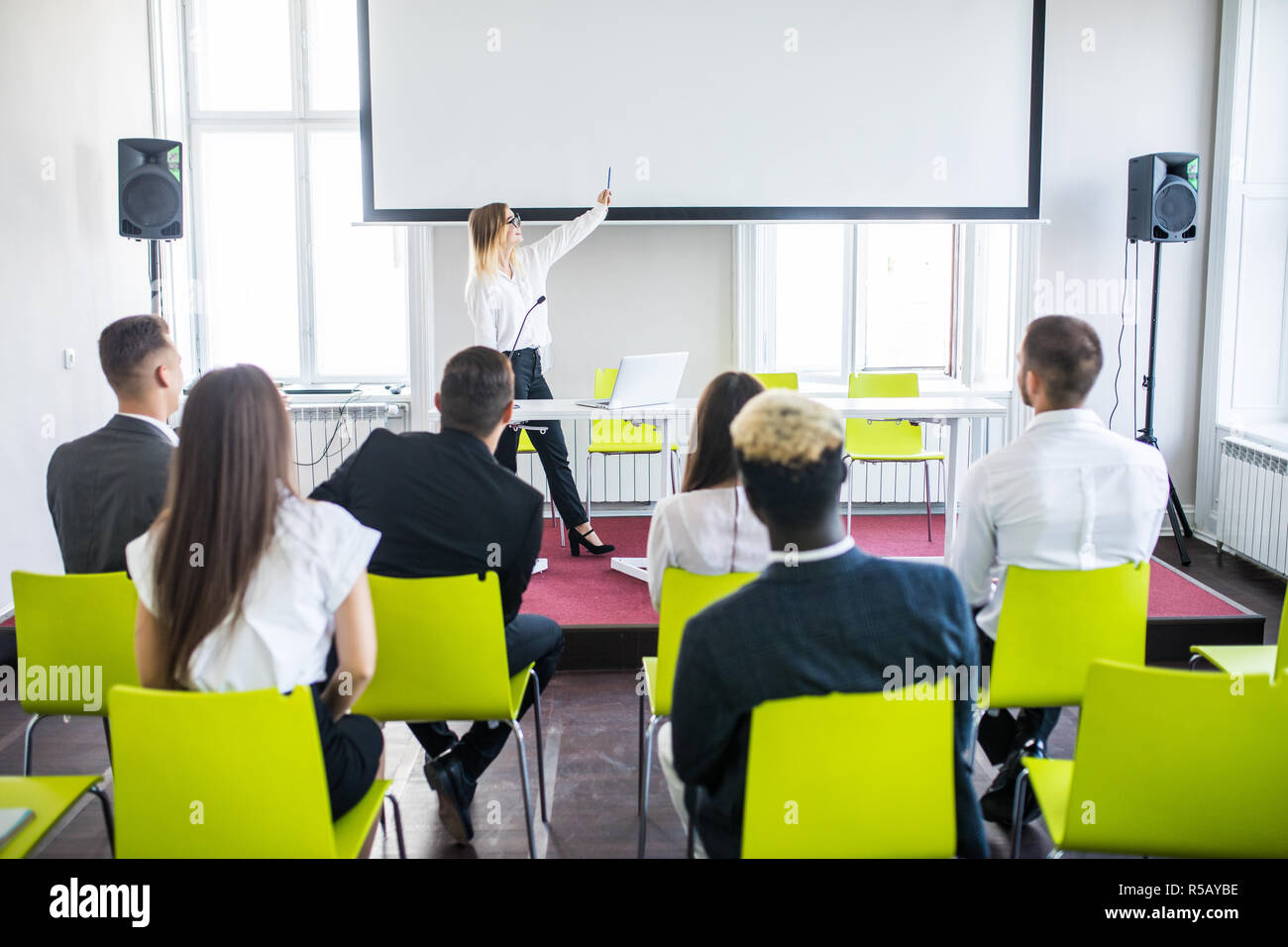 Female employee raise hand asking question to businesswoman making ...