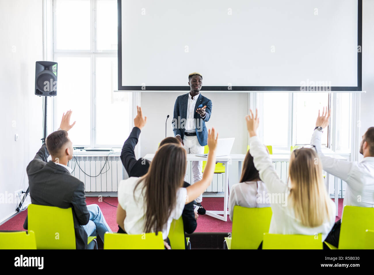 Group of successful business people at the lecture asking questions ...