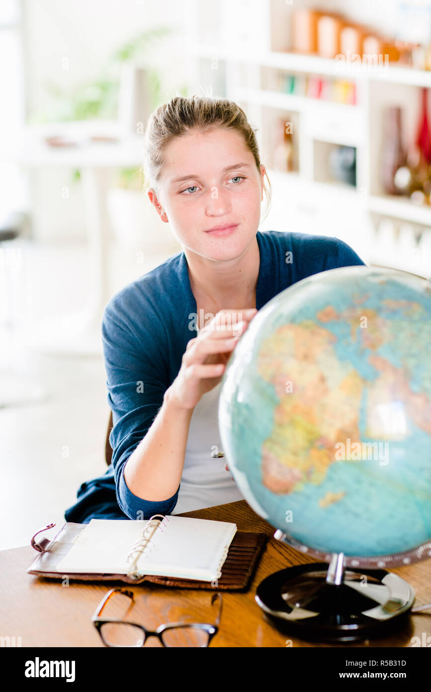 Woman looking at a map of the world Stock Photo - Alamy
