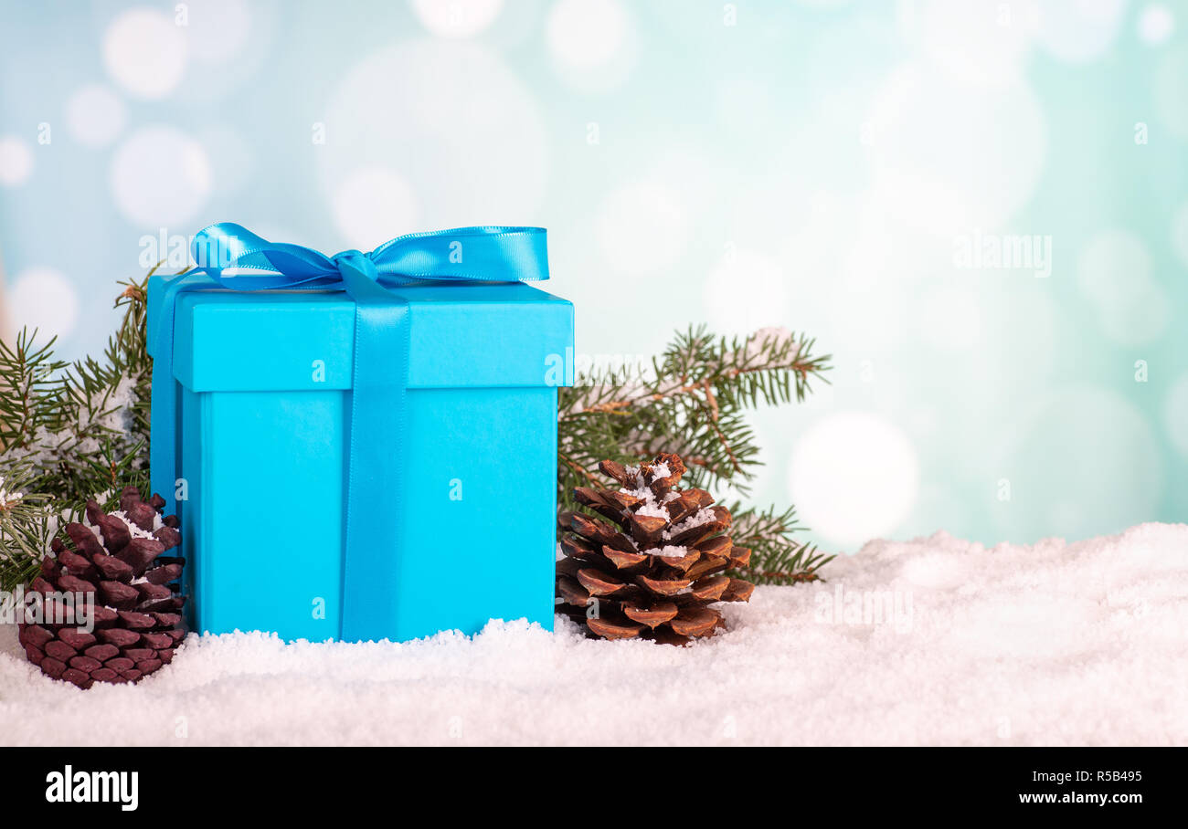 Blue Christmas gift box with pine cones and evergreen tree branches on ...