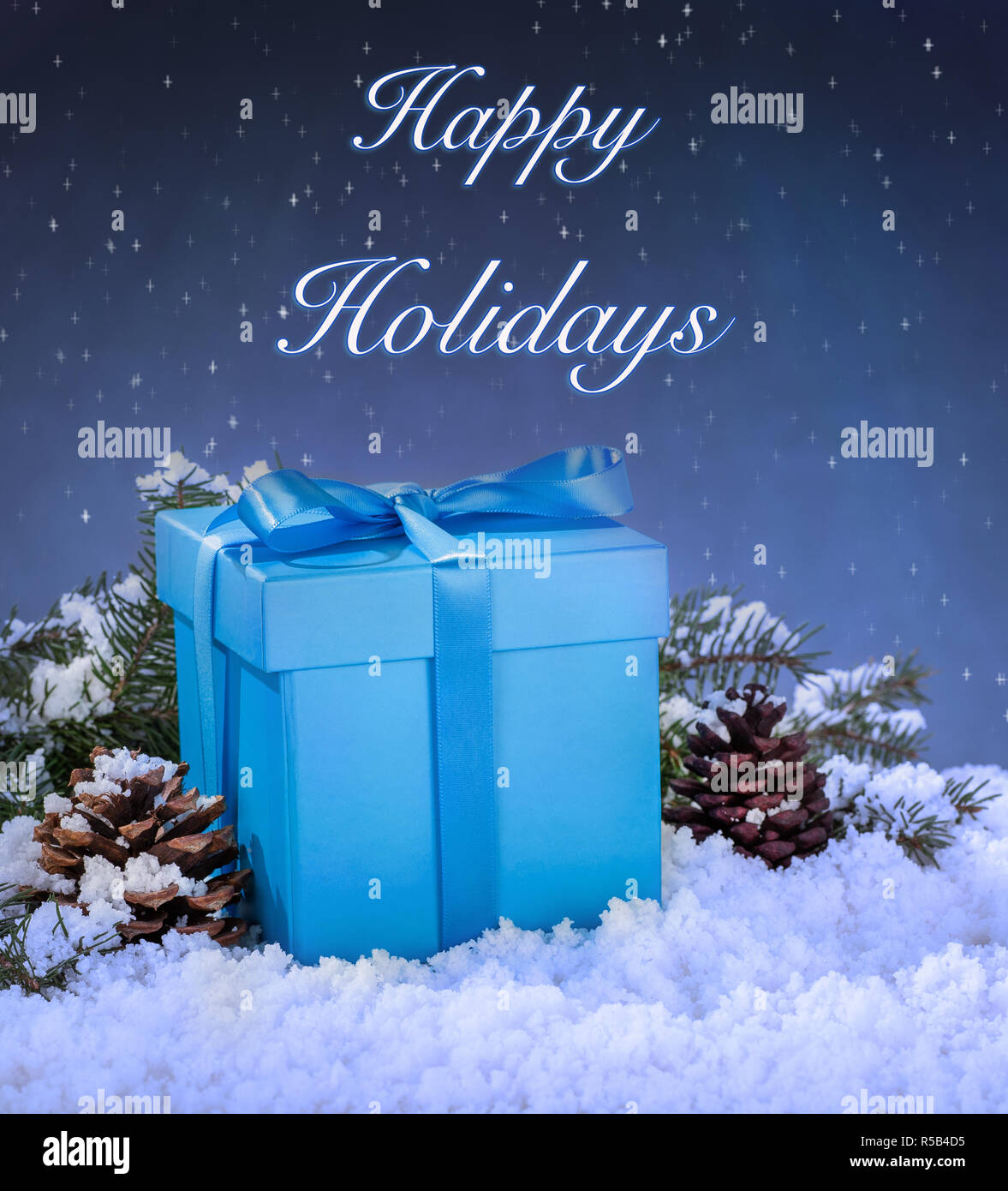 Blue Christmas gift box with pine cones on snow against a winter night ...