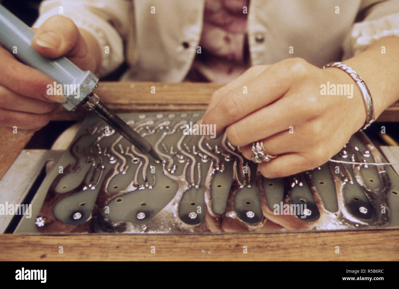 Closeup of an Employee Working with a Solderer on One of the Products ...