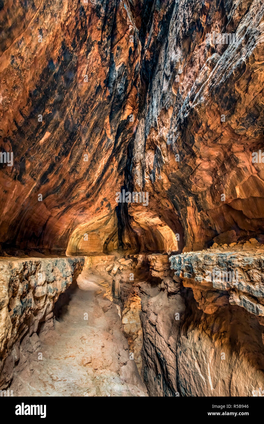 A mysterious and beautiful cave is seen from inside an arch along the ...