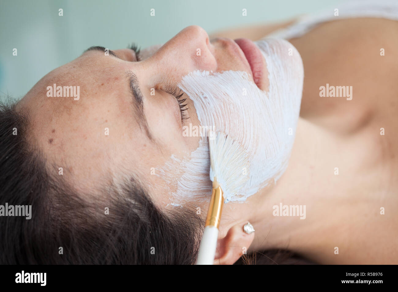 Facial mask application on woman face using a brush Stock Photo - Alamy