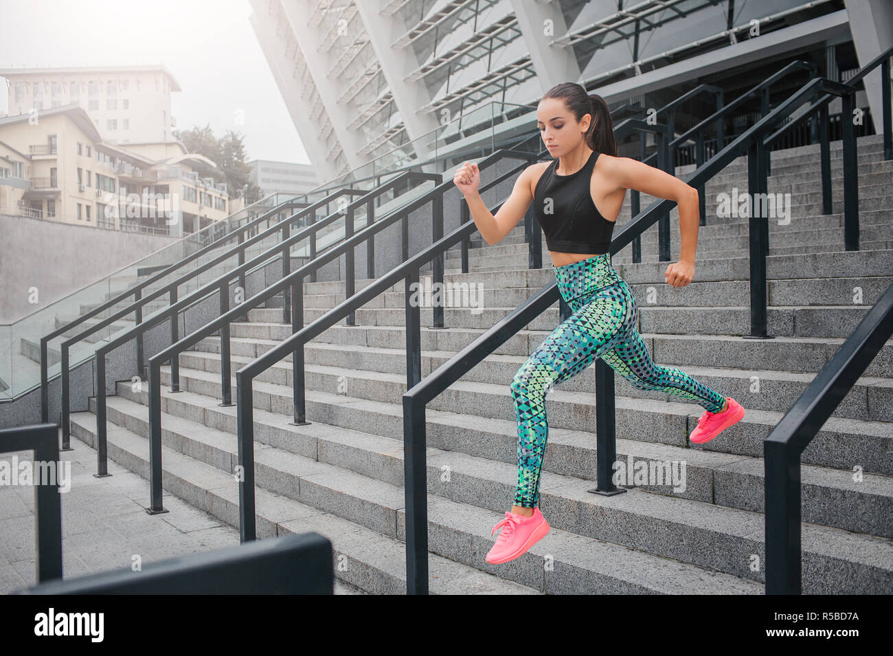 Self-motivated and concentrated young woman runs very fast. She does it ...