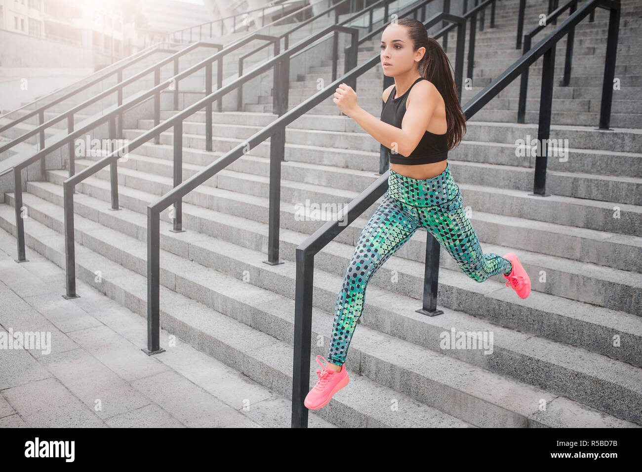 Picture of fast running model. She does it on steps. Young woman helps ...