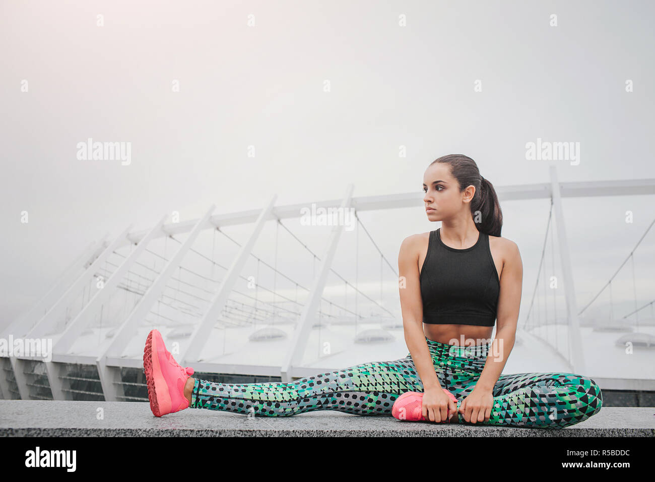 Gorgeous and attractive female athlete sits and looks to left. She ...