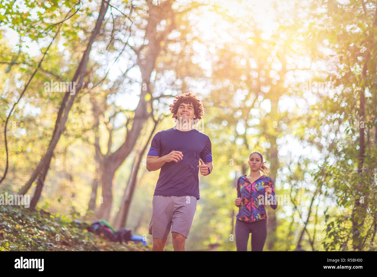 running is fun- Young Couple jogging and running outdoors in nature ...