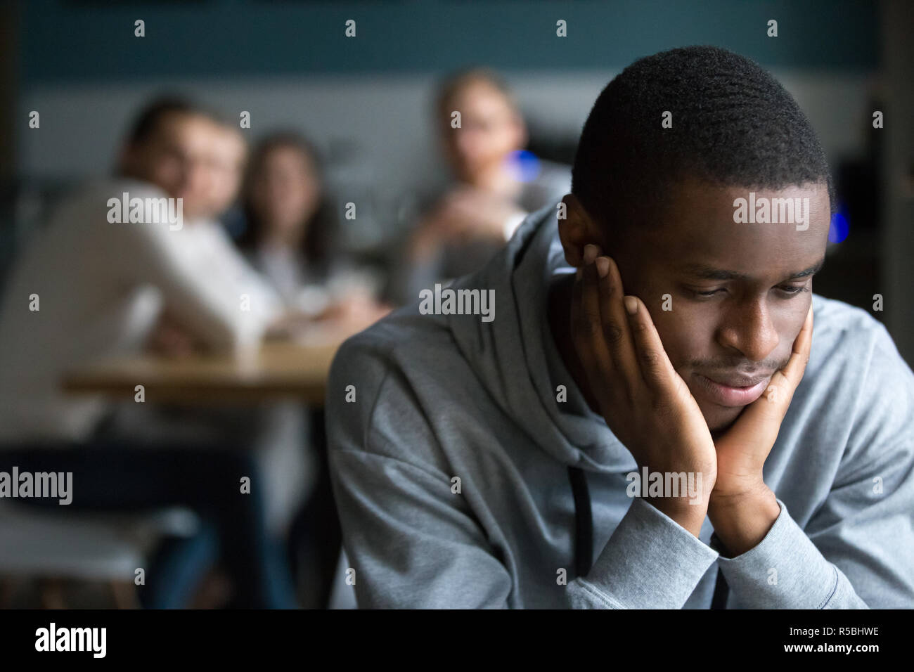 African American millennial guy feel lonely sitting alone in cafe ...