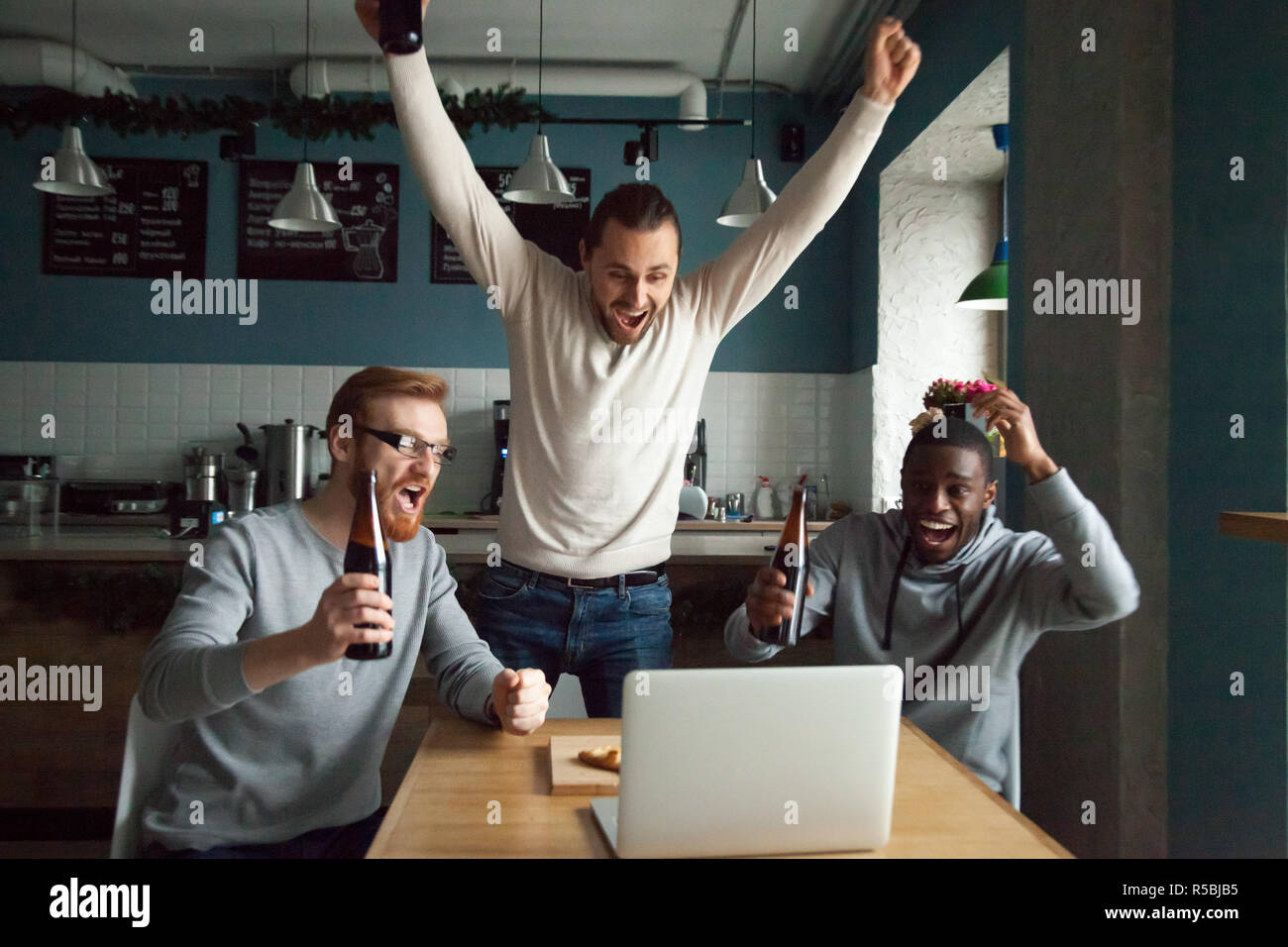 Excited millennial guys celebrating victory watching football match on ...