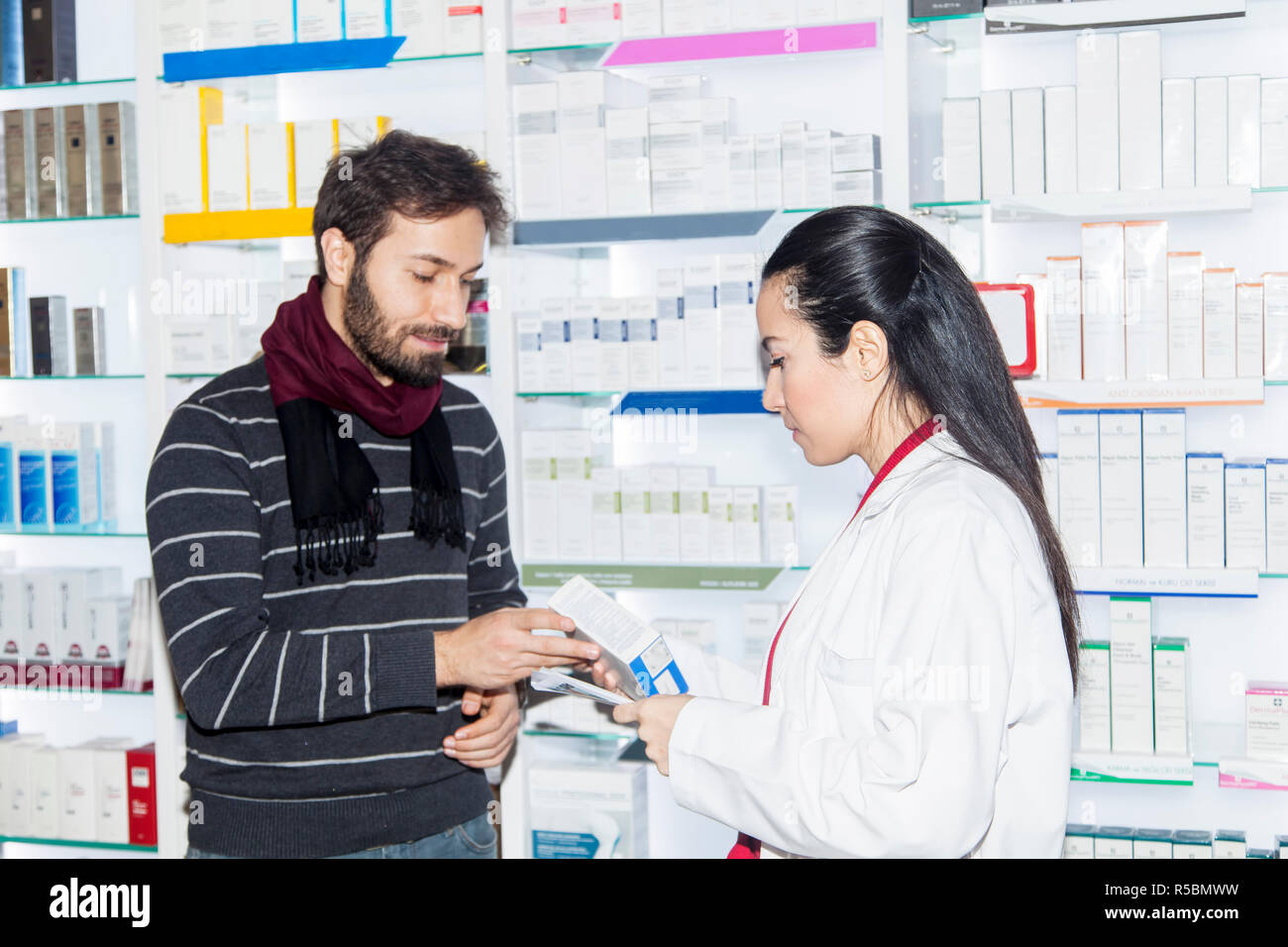 Pharmacist talking to client describing medicine Stock Photo - Alamy