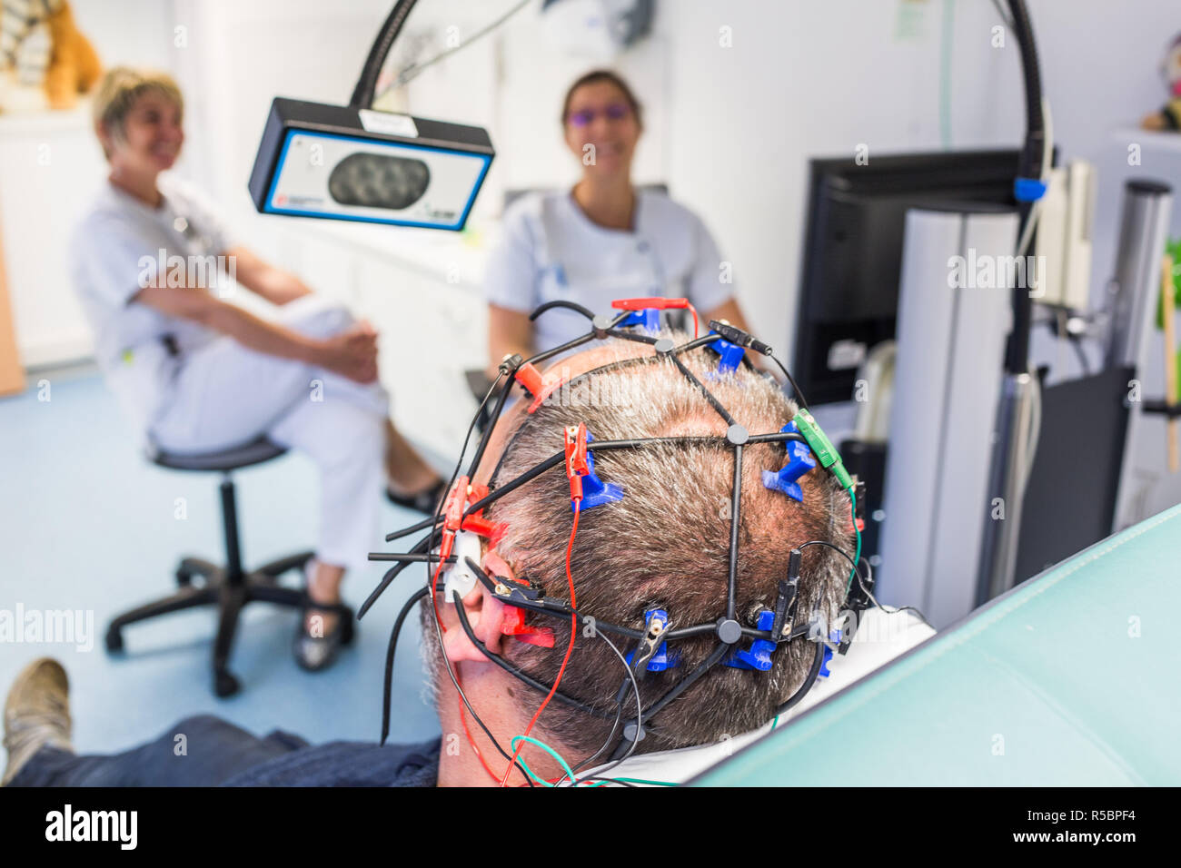 Man undergoing an electroencephalogram (EEG), epilepsy screening ...
