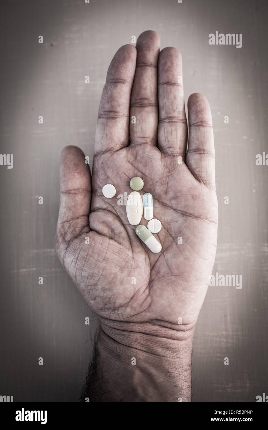 Assortment of tablets and pills in a man's hand Stock Photo - Alamy