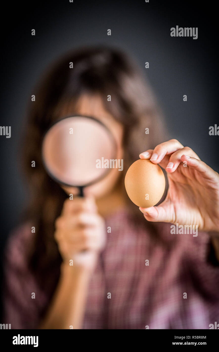 Woman watching an egg with a magnifying glass Stock Photo - Alamy