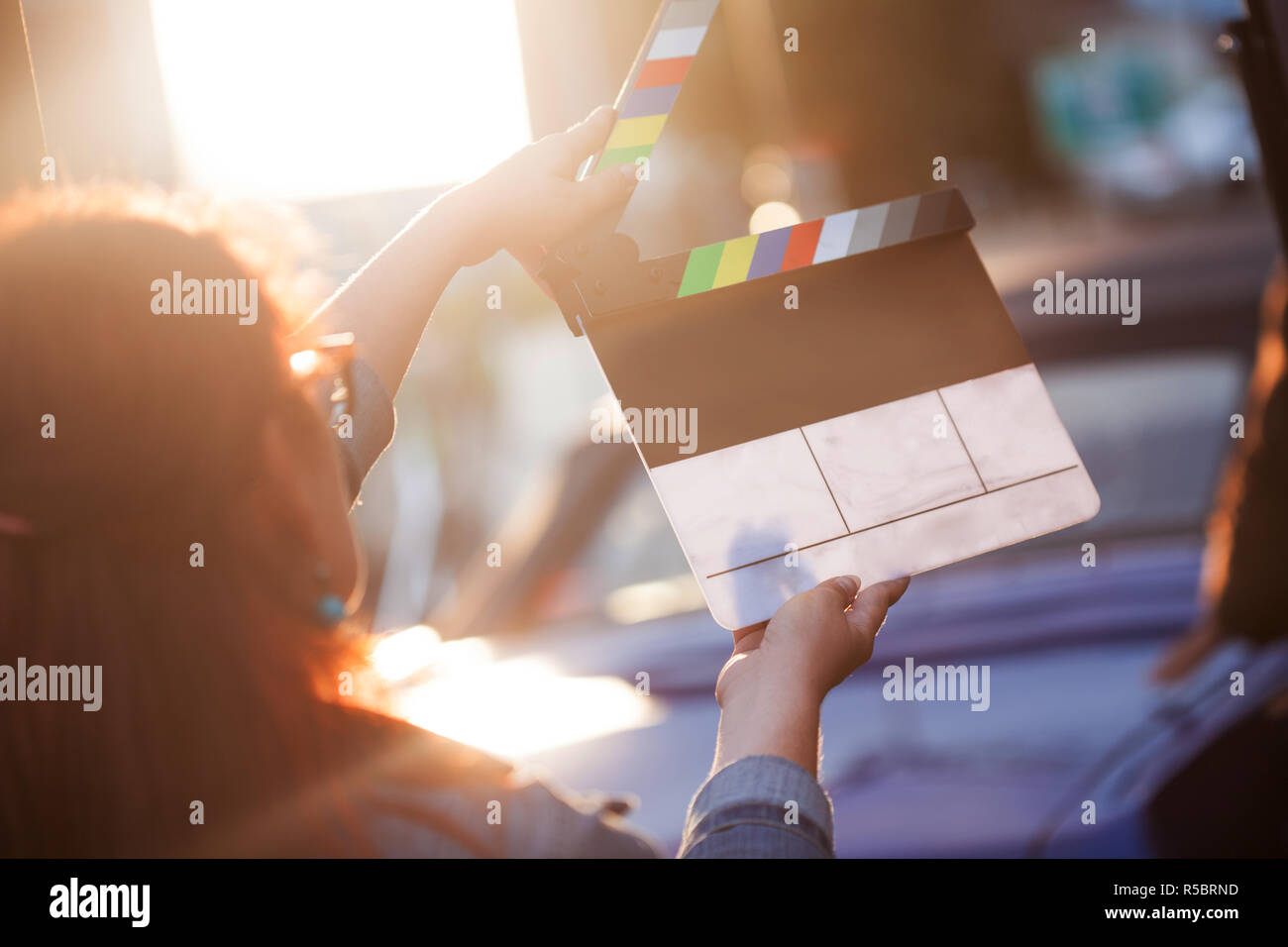 Filming on location. Woman holding a clapperboard in front of the ...