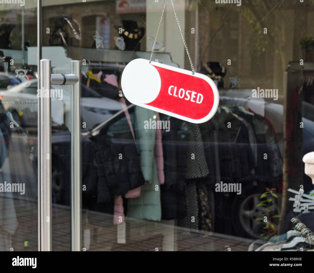 Glass door of a clothing store with a "closed" sign. Concept of the era ...