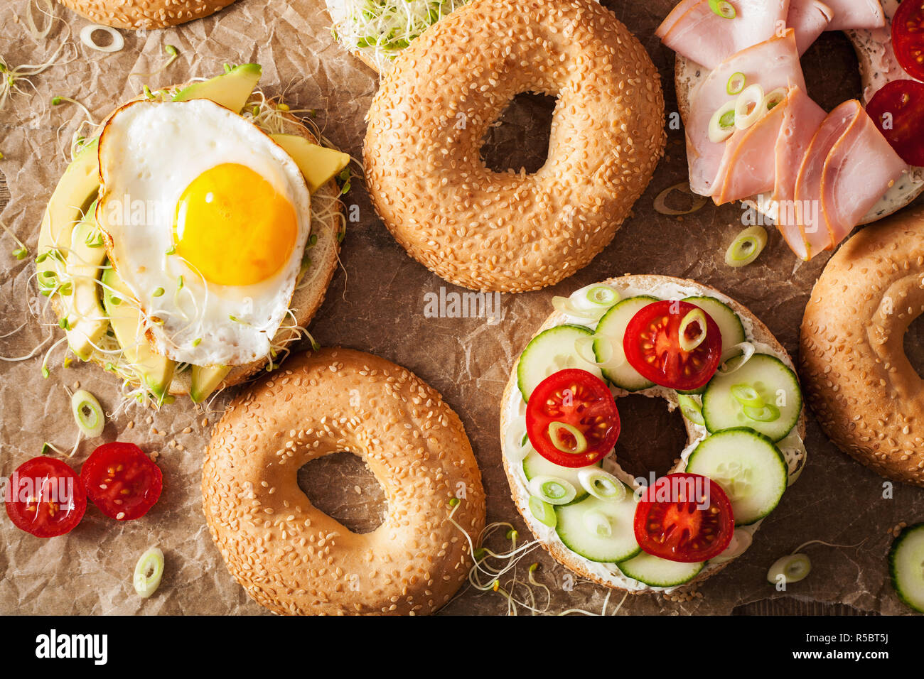 variety of sandwiches on bagels: egg, avocado, ham, tomato, soft cheese ...