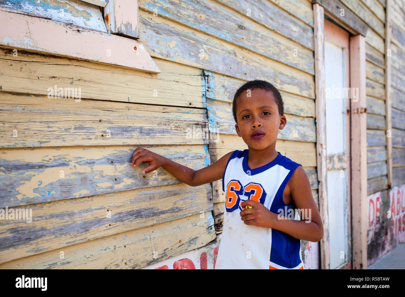 Dominican Republic, Rio San Juan, Boy standing by old wooden house ...