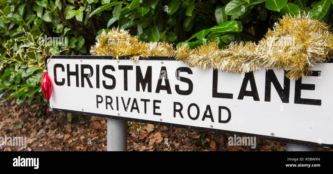 Christmas Lane road sign decorated with baubles, holly and tinsel ...