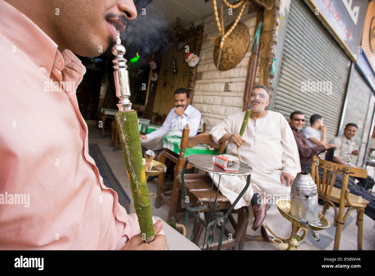 Egypt, Aswan, Old Town, Men smoking water pipe in street cafe Stock ...