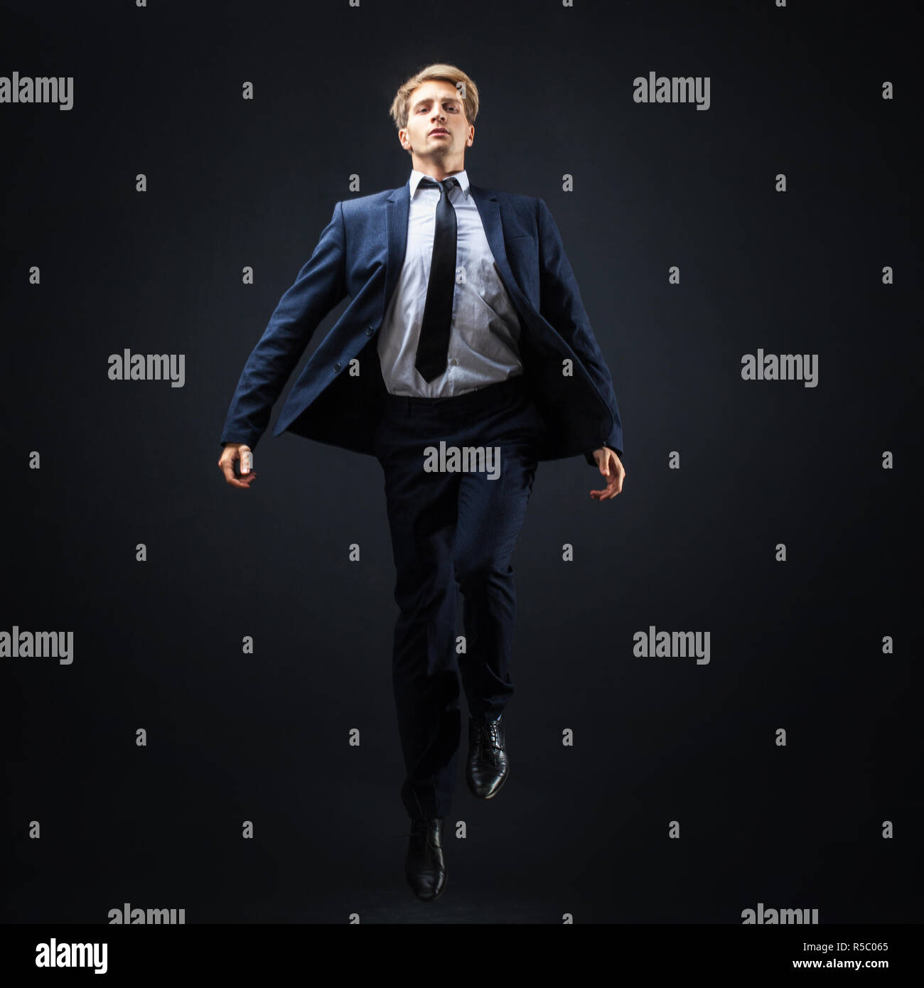 Businessman on a dark background. A leap into the unknown, an ambitious ...