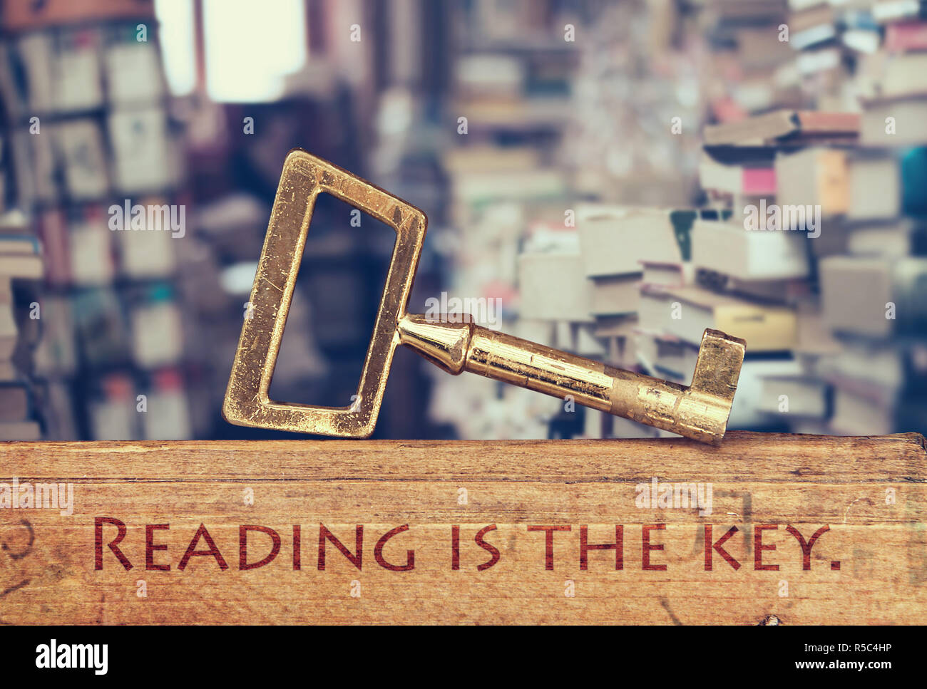 Reading is the key. Symbolic key standing on a wooden desk in the ...