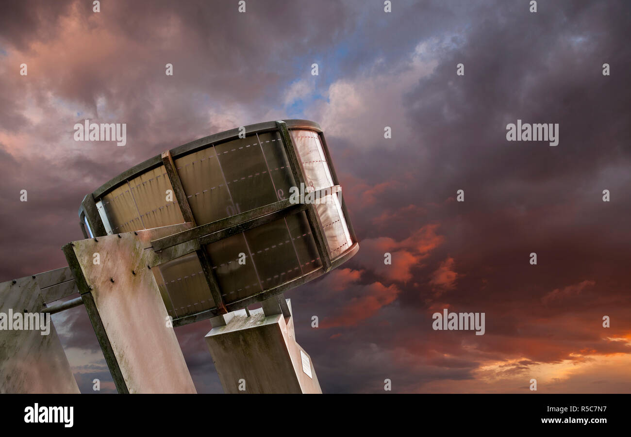 modern sundial outdoors built in metal under a cloudy sky at sunset ...