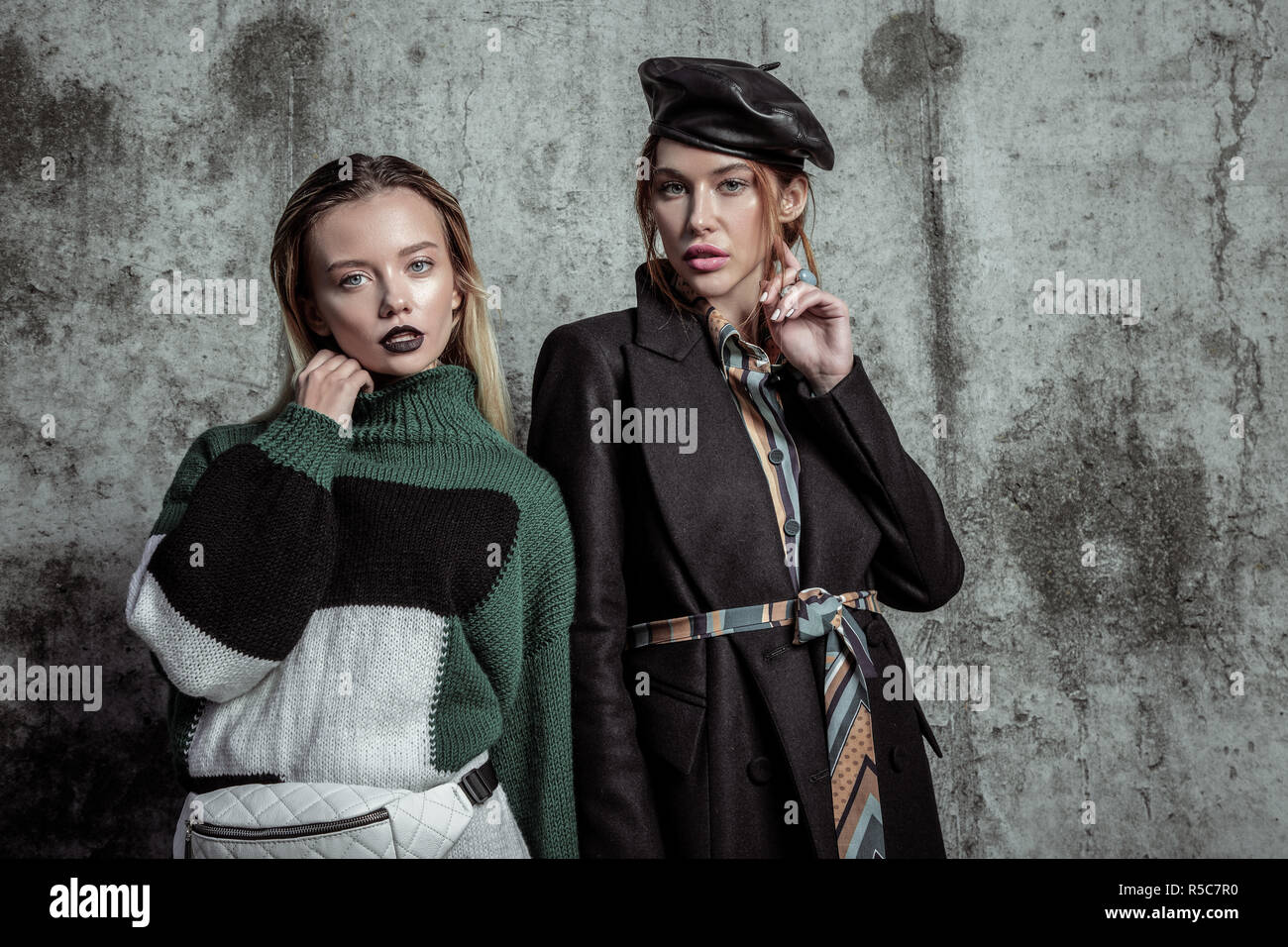 New collection. Two professional models posing near wall wearing ...