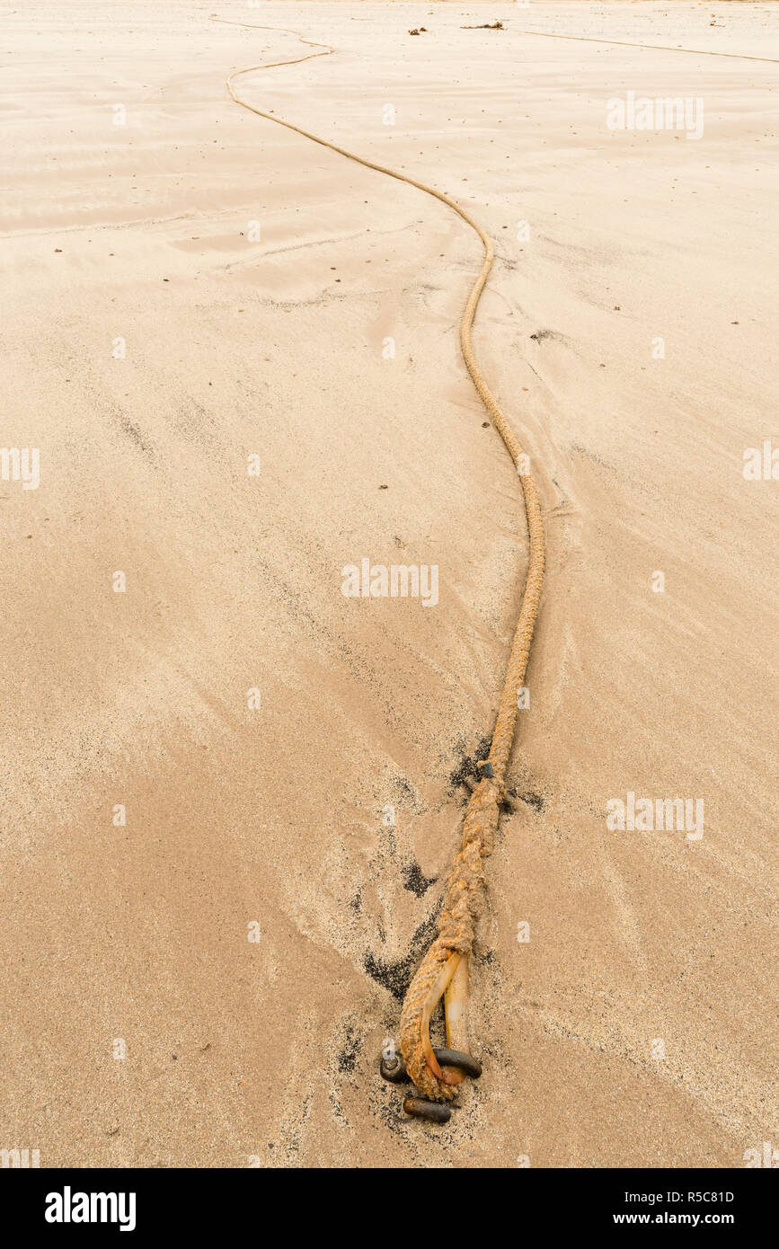A boat mooring rope trailing snake-like in the sand, taken with a tilt ...