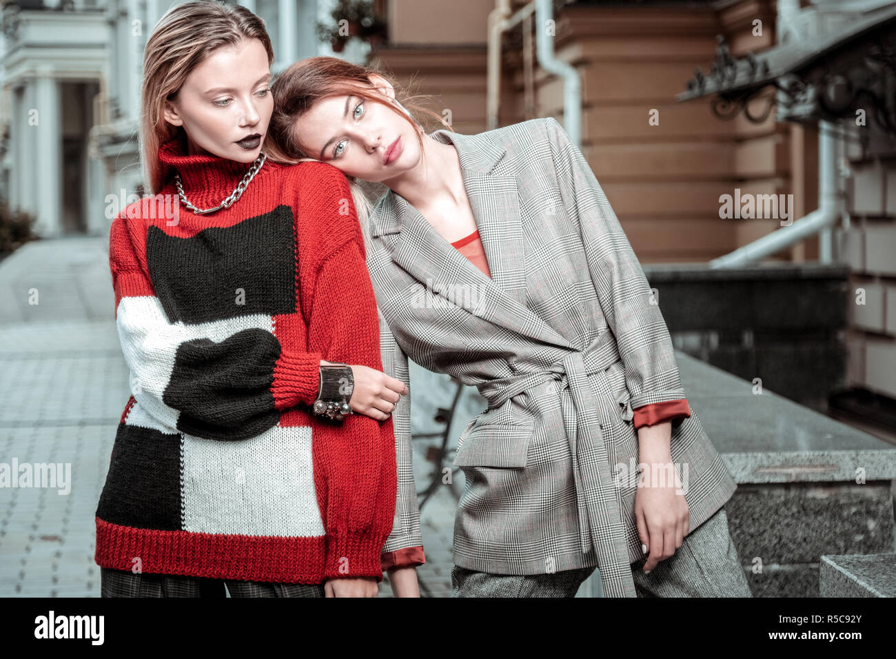 Lean on shoulder. Red-haired fashionable woman leaning on shoulder of ...