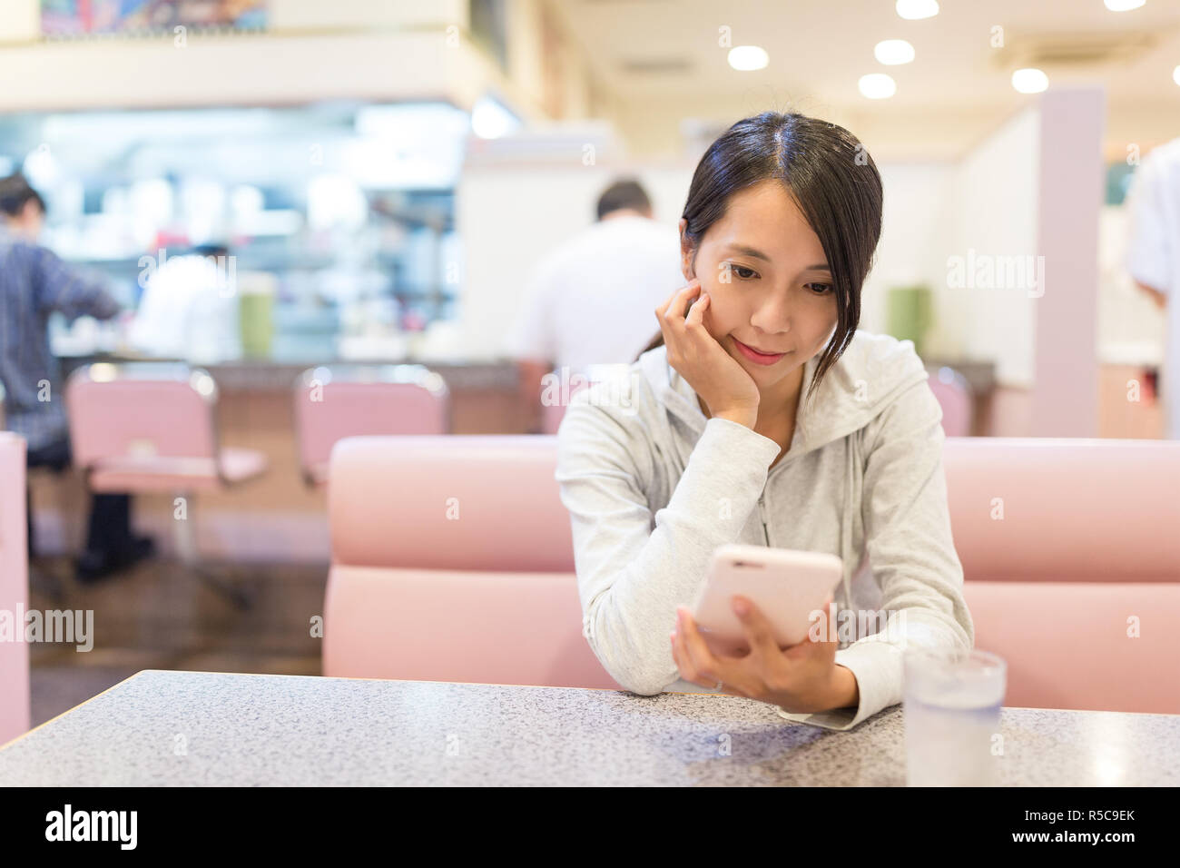Woman use of mobile phone in a restaurant Stock Photo - Alamy