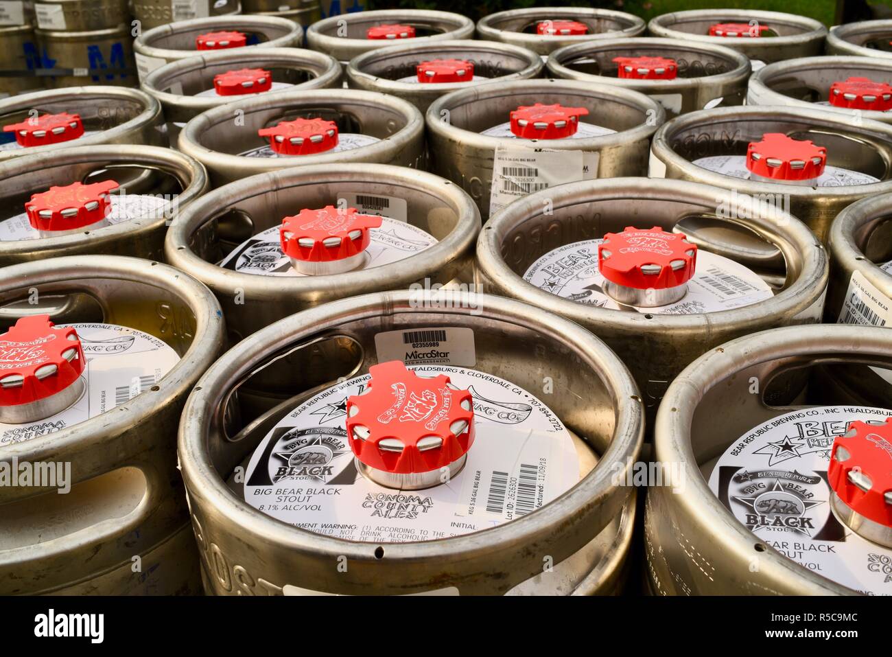 Close up of silver metal, full beer kegs filled, with branded and ...