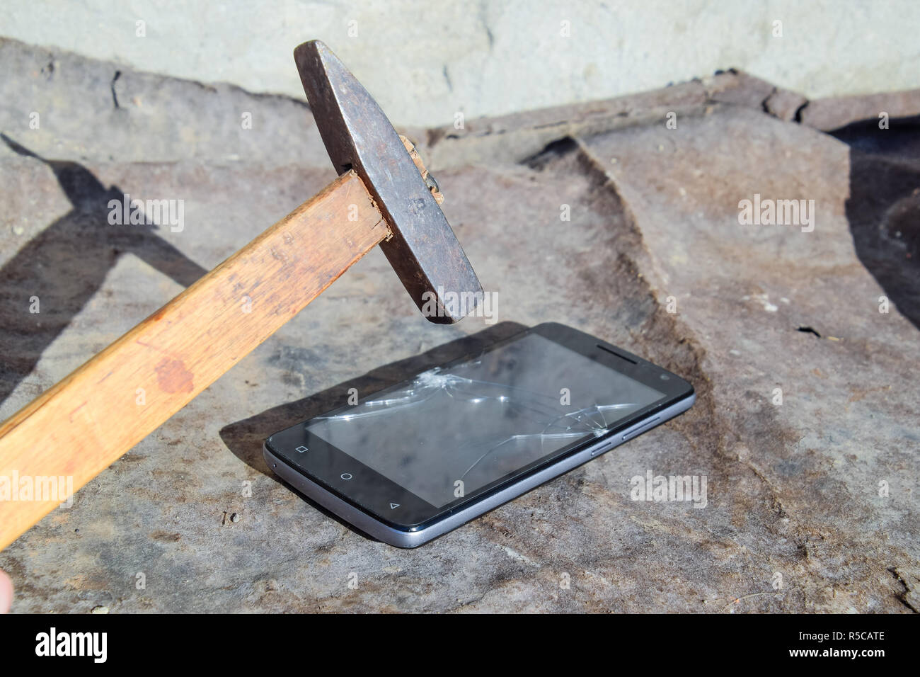 Hammer and smartphone. The screen of the smartphone, a broken ha Stock ...