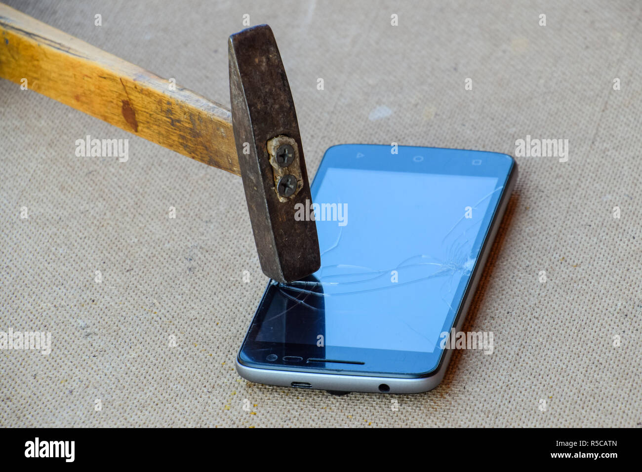 Hammer and smartphone. The screen of the smartphone, a broken ha Stock ...