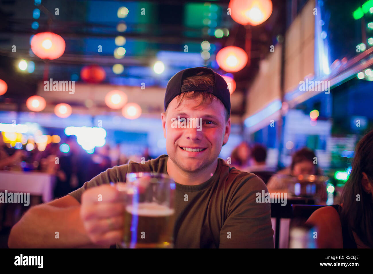 Man drinks beer. Side view of handsome young guy drinking lager pint ...