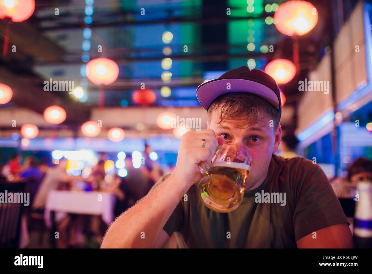 Man drinks beer. Side view of handsome young guy drinking lager pint ...