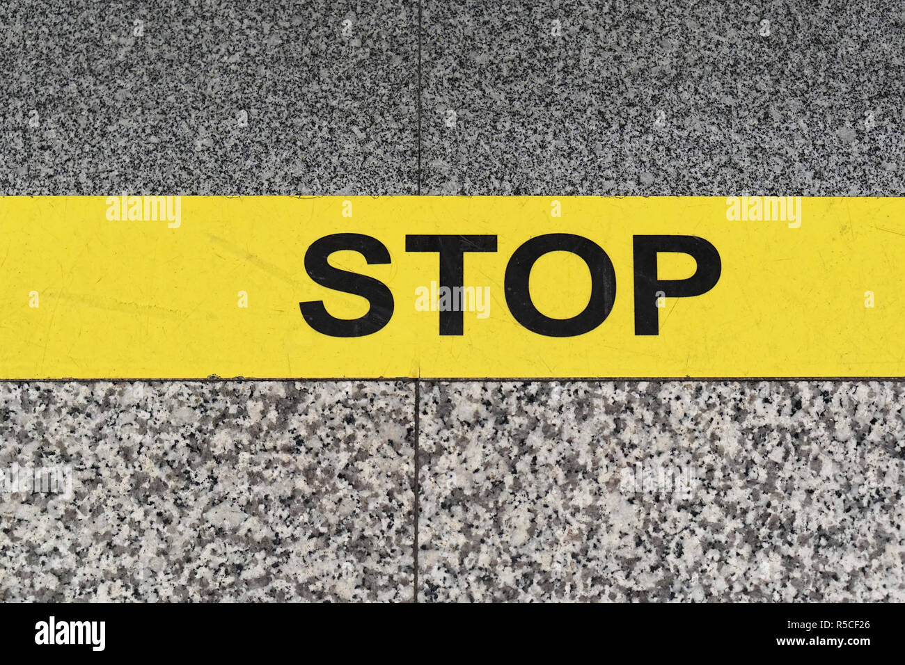 Stop sign yellow line at marble floor warning Stock Photo - Alamy