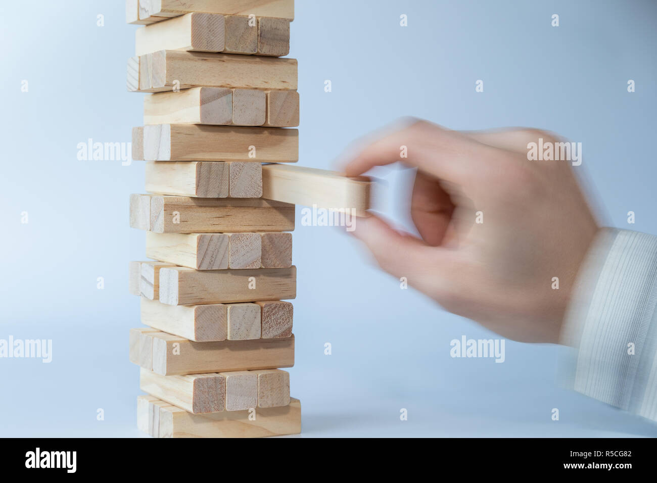 Man's hand taking first block or putting the last block to a sturdy ...
