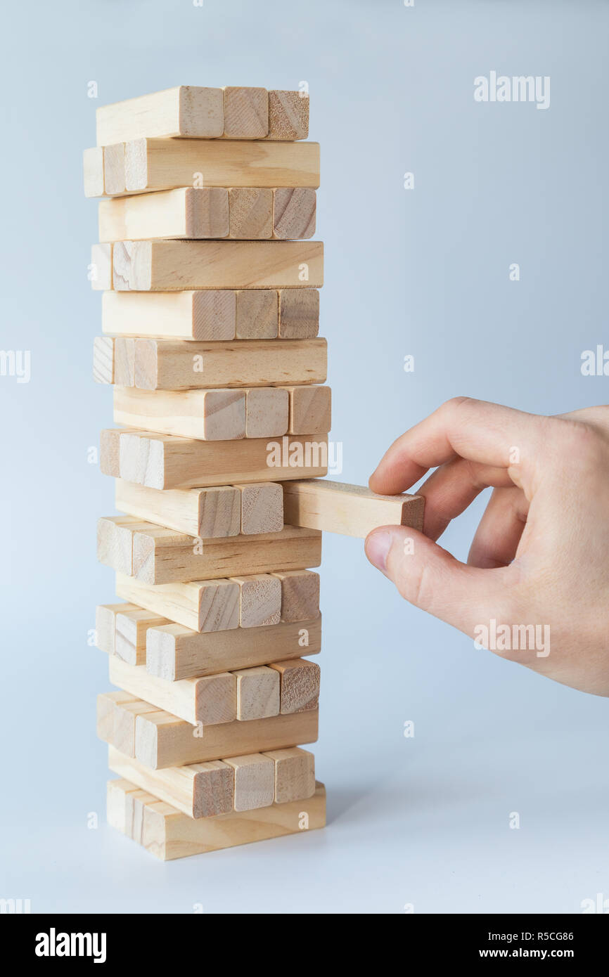 Man's hand taking first block or putting the last block to a sturdy ...