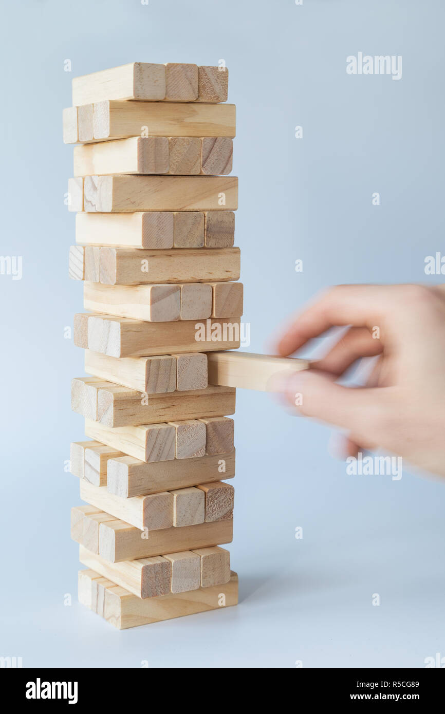 Hand taking first block or putting last block to a sturdy tower of ...