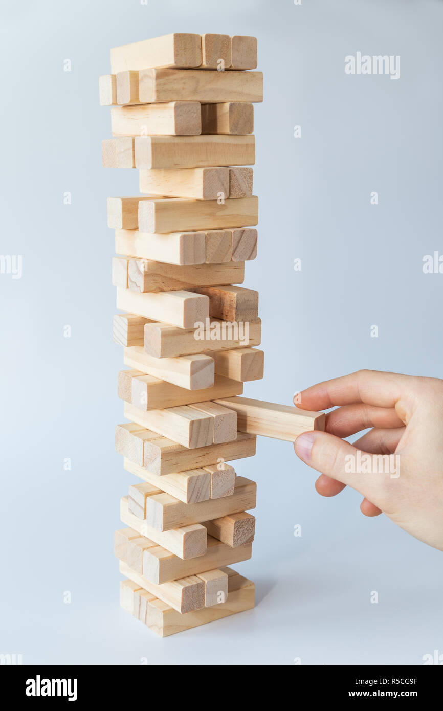 Man's hand taking or putting a block to an unstable and incomplete ...