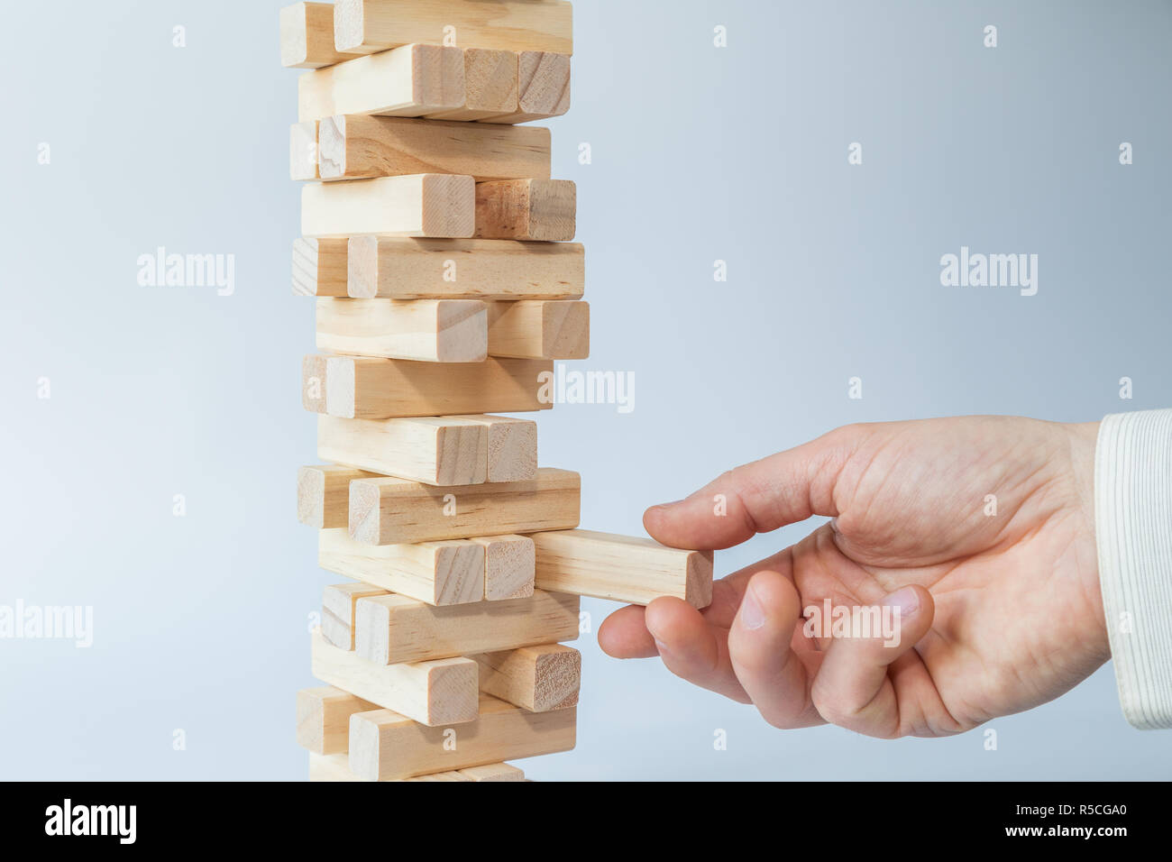 Man's hand taking or putting a block to an unstable and incomplete ...