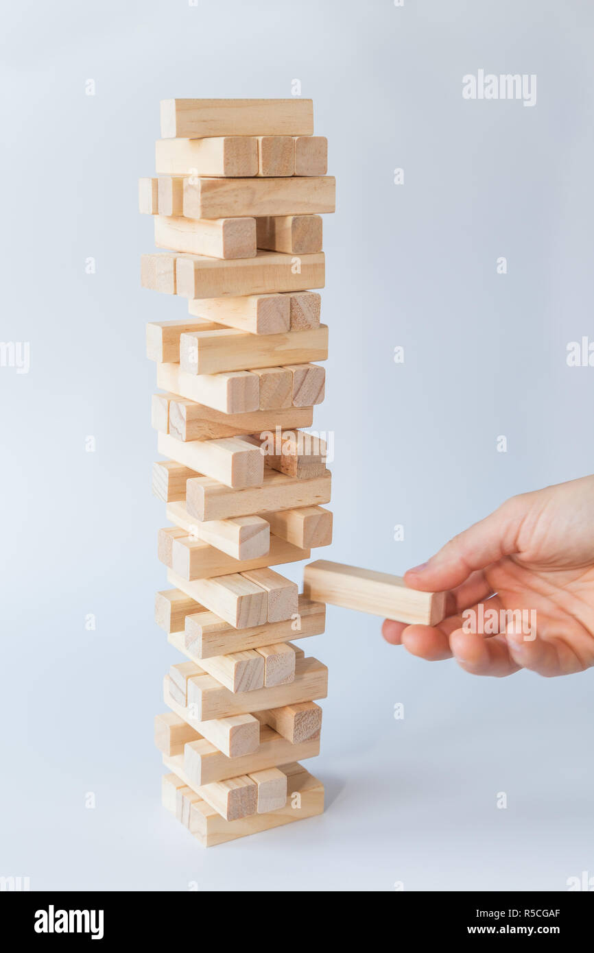 Man's hand taking or putting a block to an unstable and incomplete ...