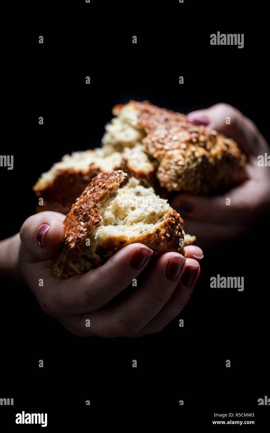 Woman's hands sharing a loaf of bread Stock Photo - Alamy