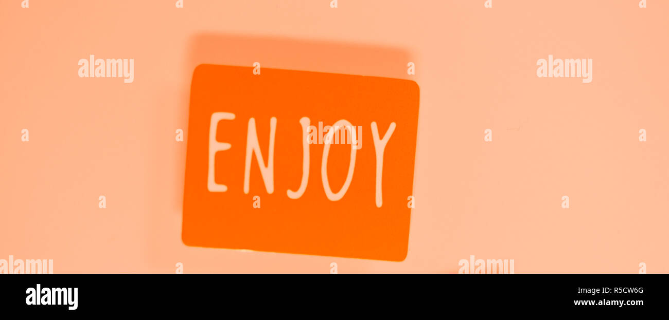 Enjoy greetings message written in letters on present tag Stock Photo ...
