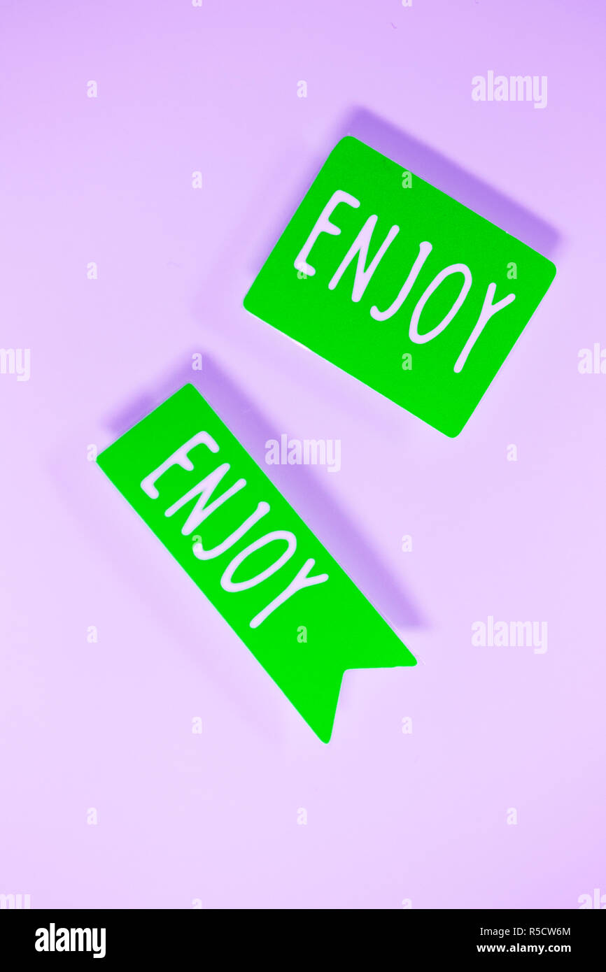 Enjoy greetings message written in letters on present tag Stock Photo ...