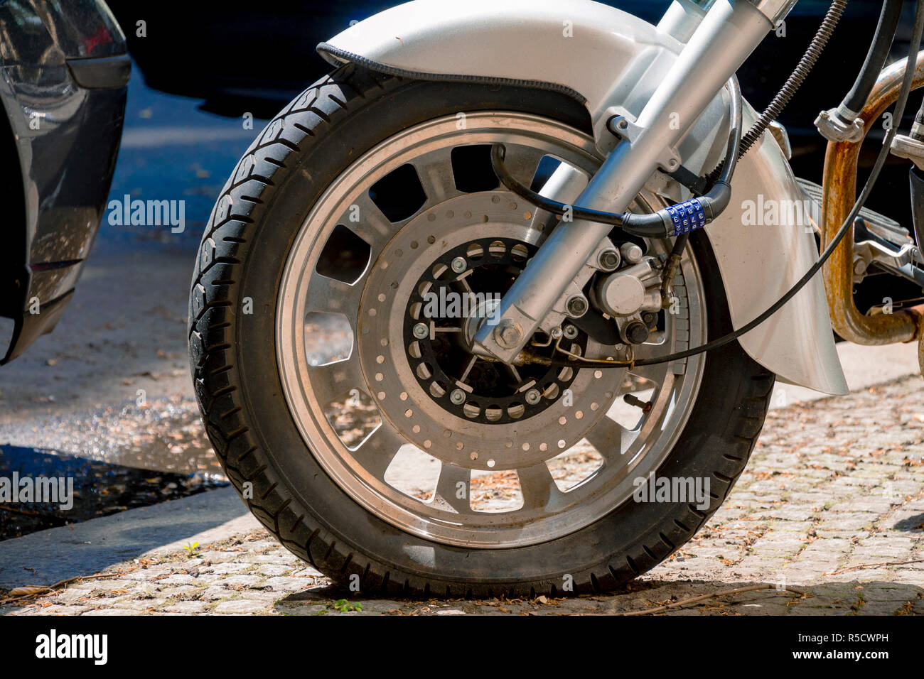 Security number padlock blocking motorcycle wheel on the street Stock ...