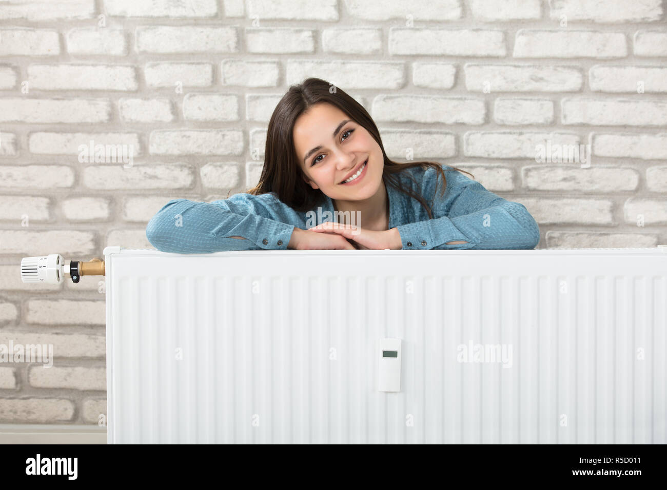 Woman Behind The Heating Radiator Stock Photo - Alamy