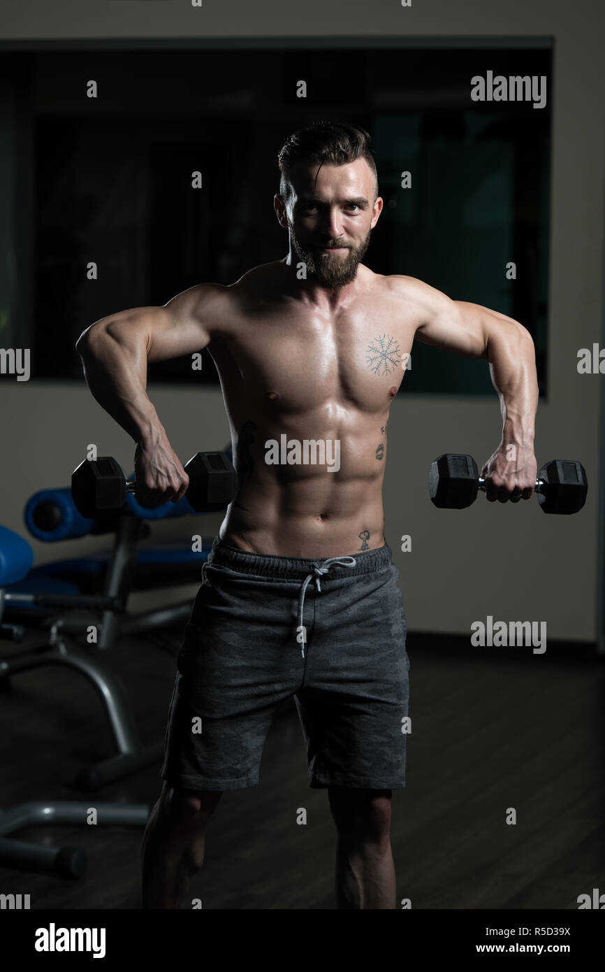 Athlete Working Out Shoulders With Dumbbells in a Gym Stock Photo - Alamy